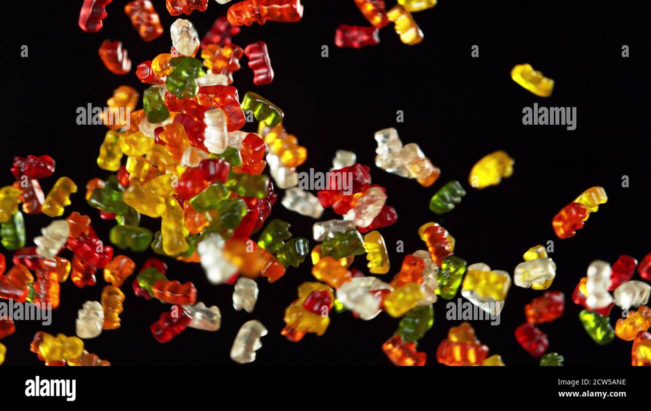 Freeze motion of flying candies up in the air. Isolated on black ...