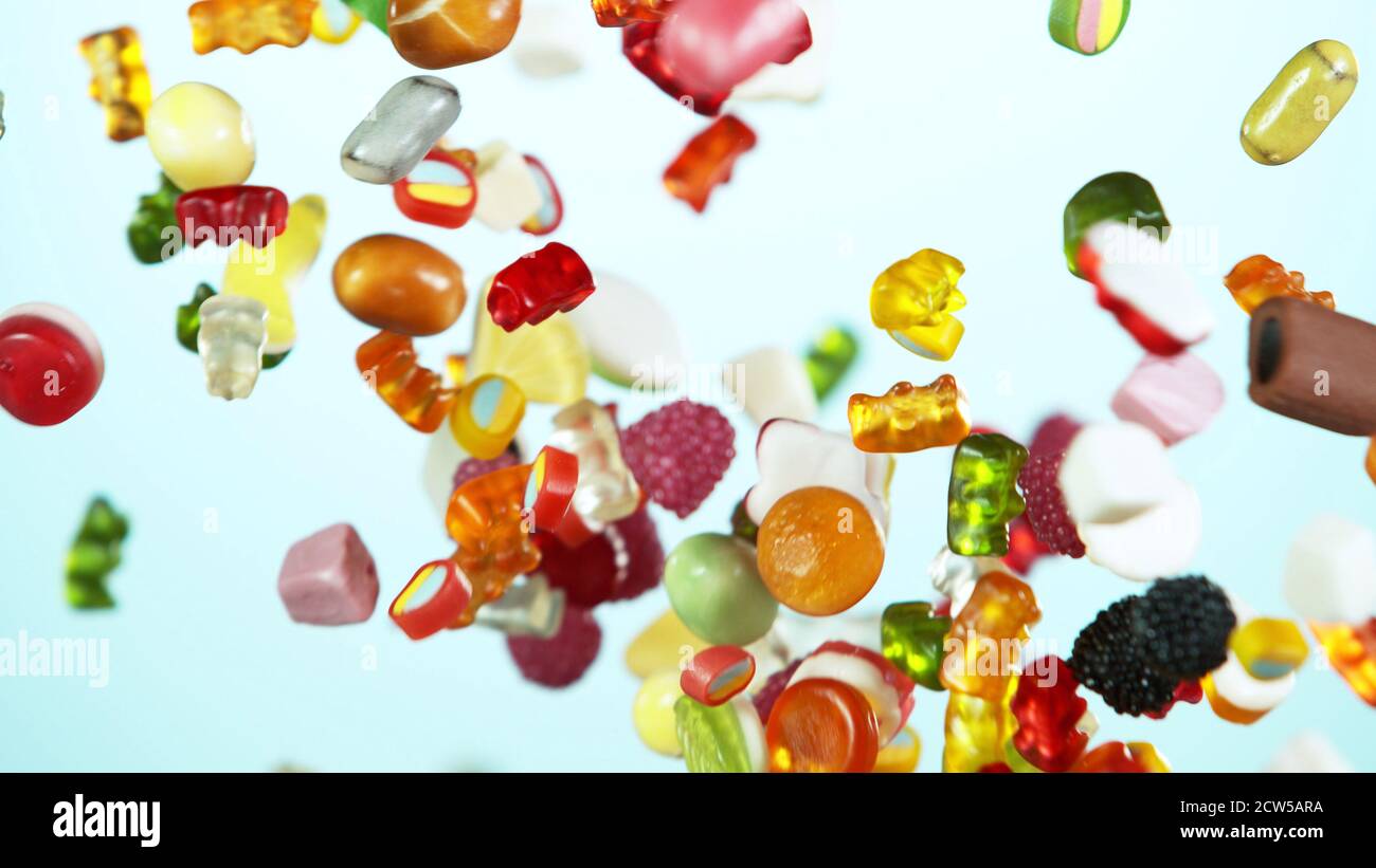 Freeze motion of flying candies up in the air. Isolated on white ...