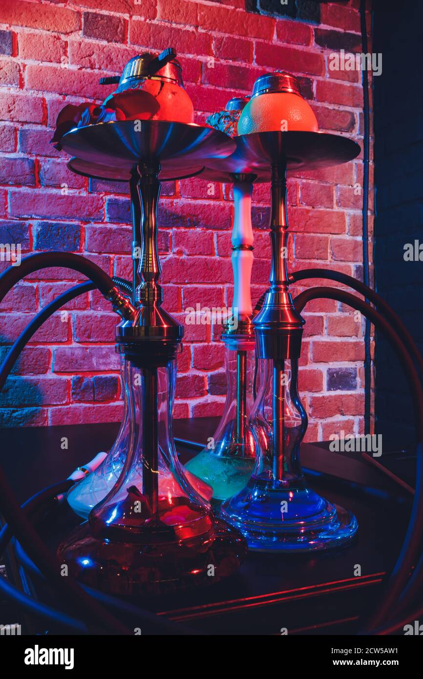 Red shisha hookah with smoke and red sparks on wood table brick, art ...