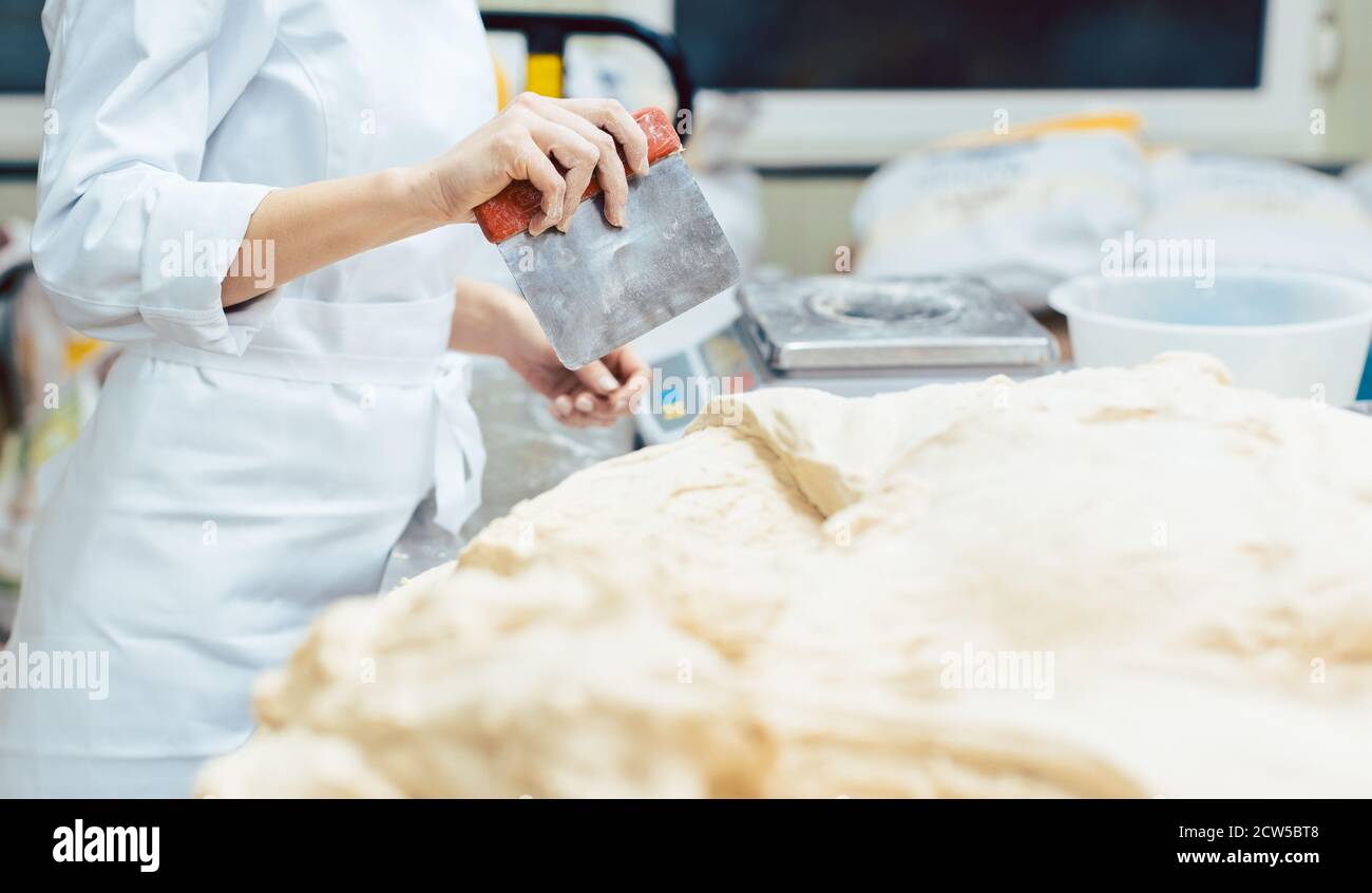 Baker measuring dough to make a bread Stock Photo - Alamy