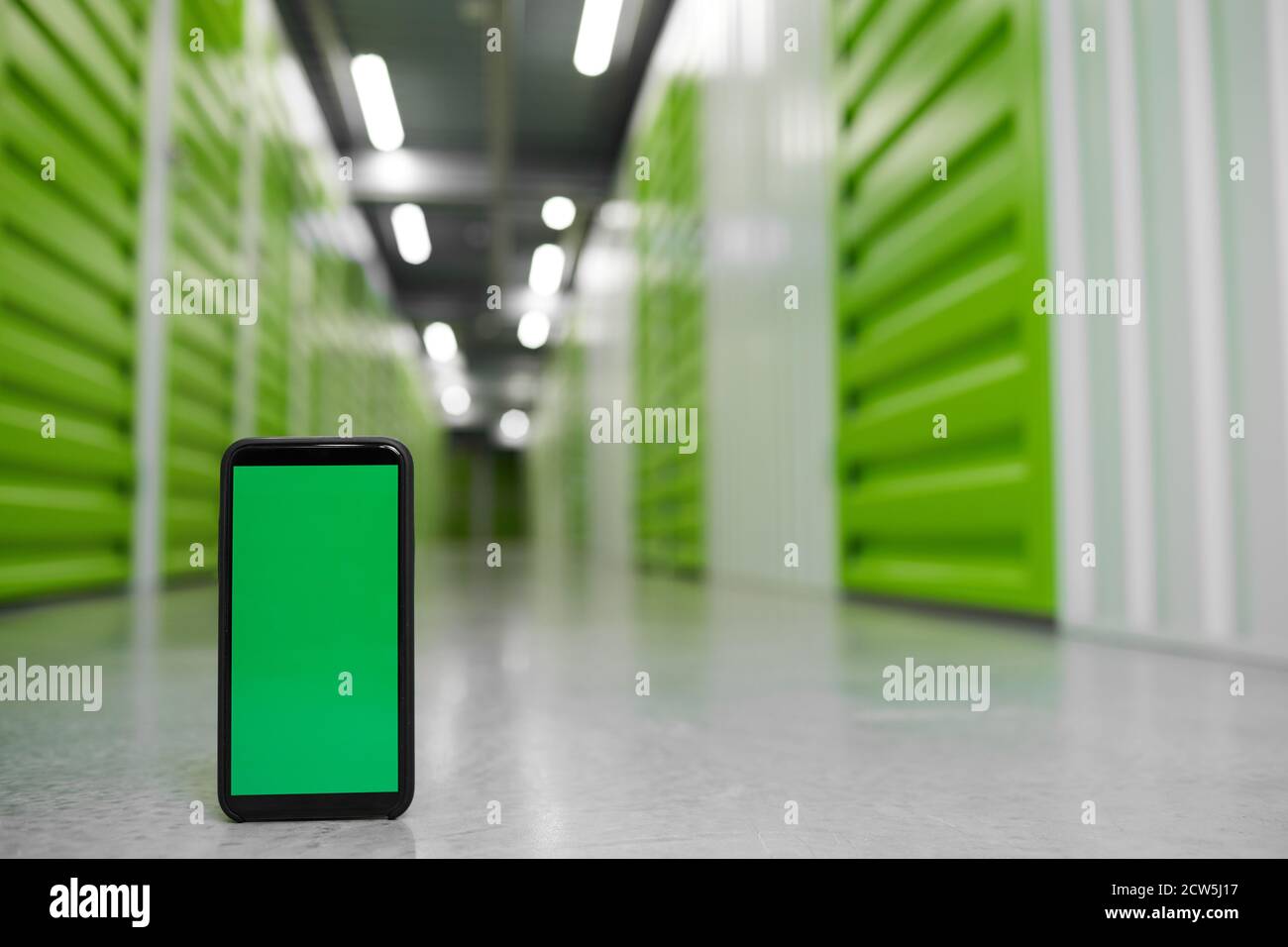 Background image of storage facility with green screen smartphone in ...