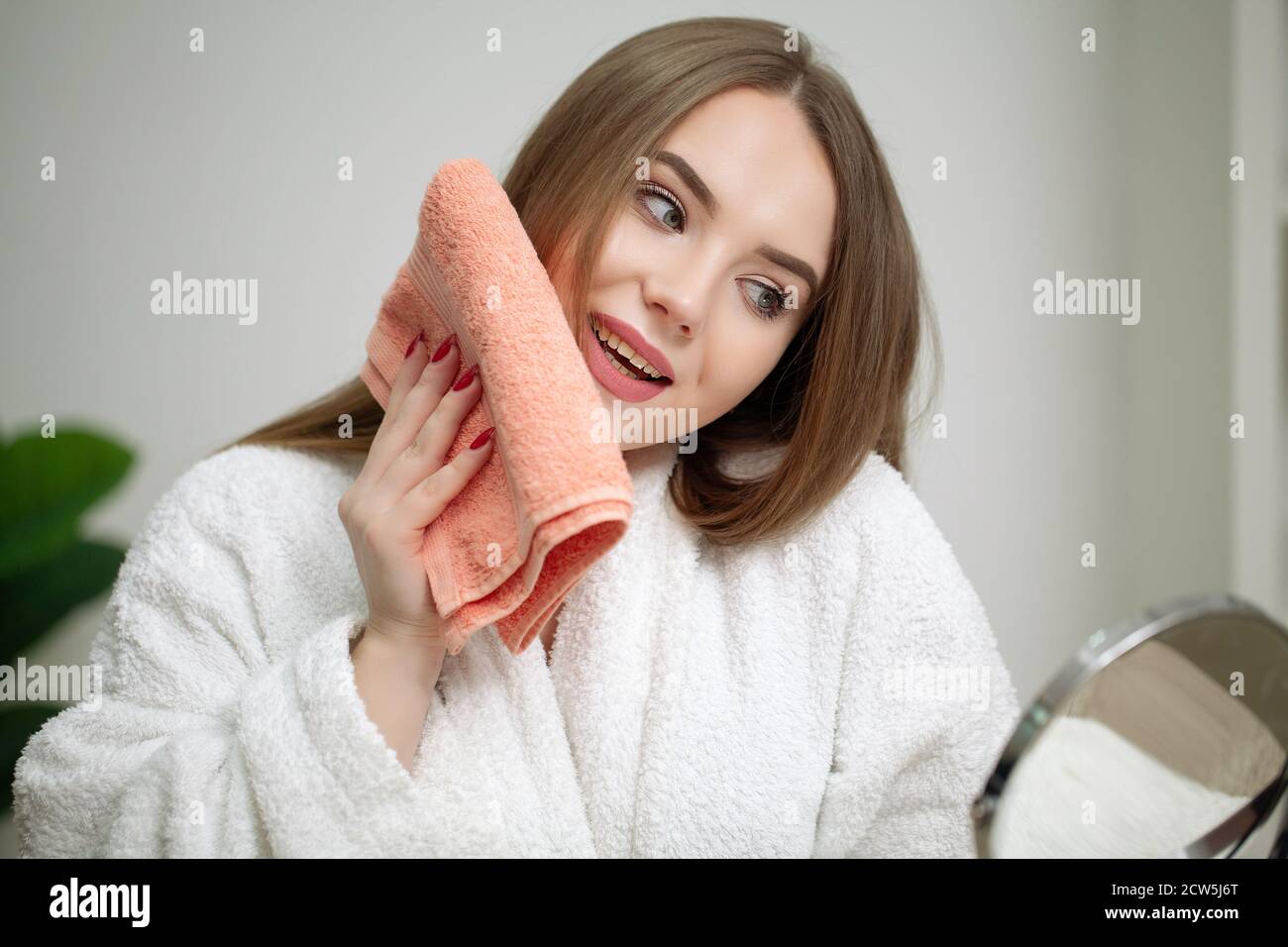 Cute woman cleaning facial skin with towel after washing face portrait ...