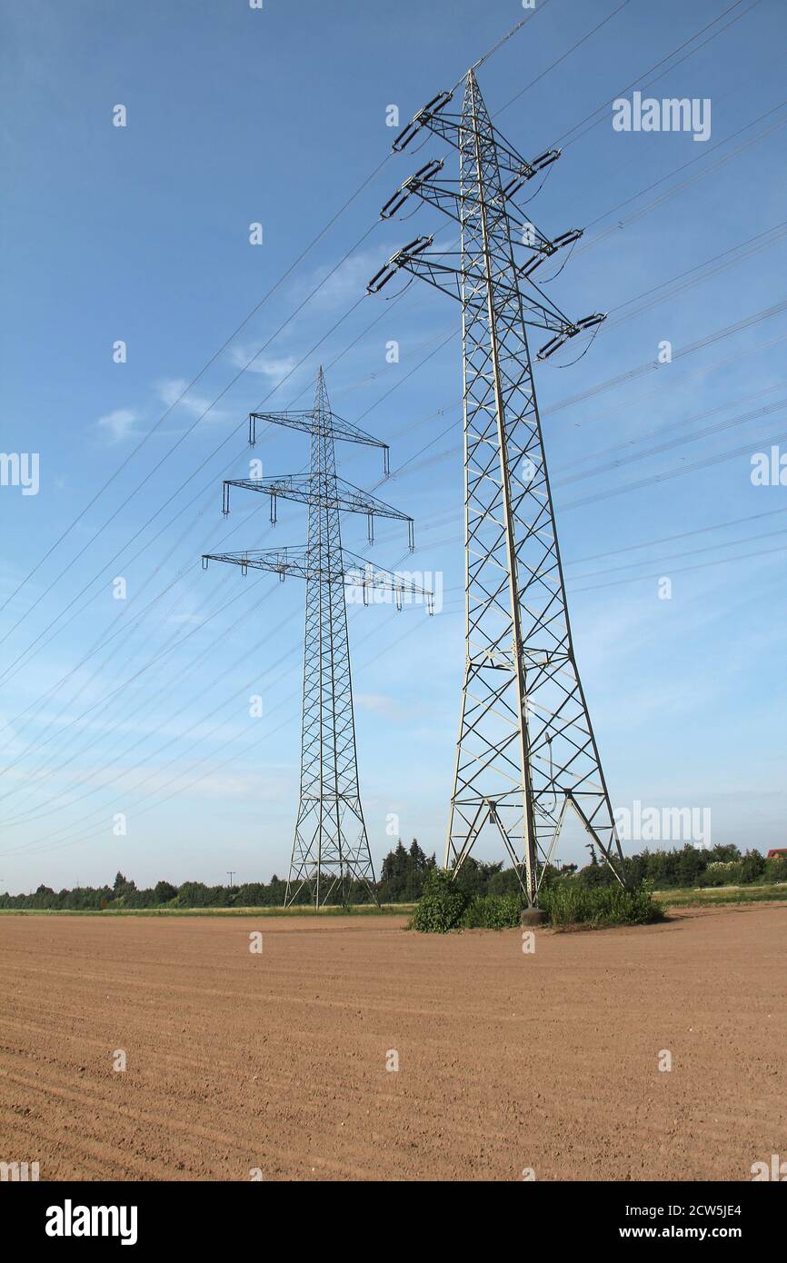 Vertical shot of a power tower in the field at daytime Stock Photo - Alamy