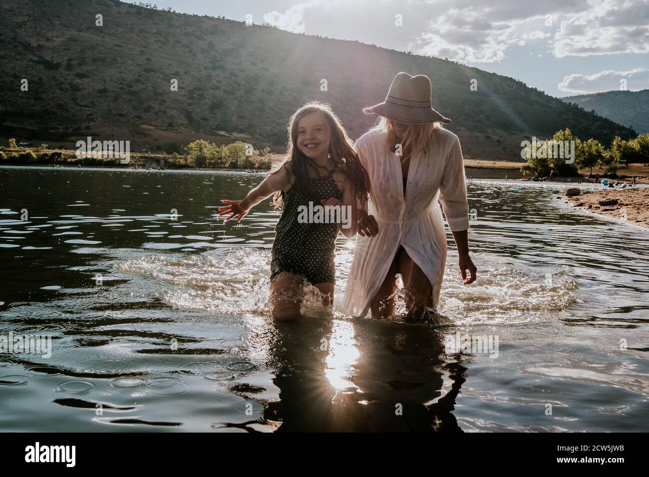 Woman chasing smiling girl in knee deep water Stock Photo - Alamy