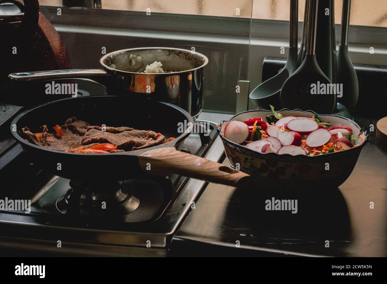 cook with a salad bowl and pans and ladles Stock Photo - Alamy