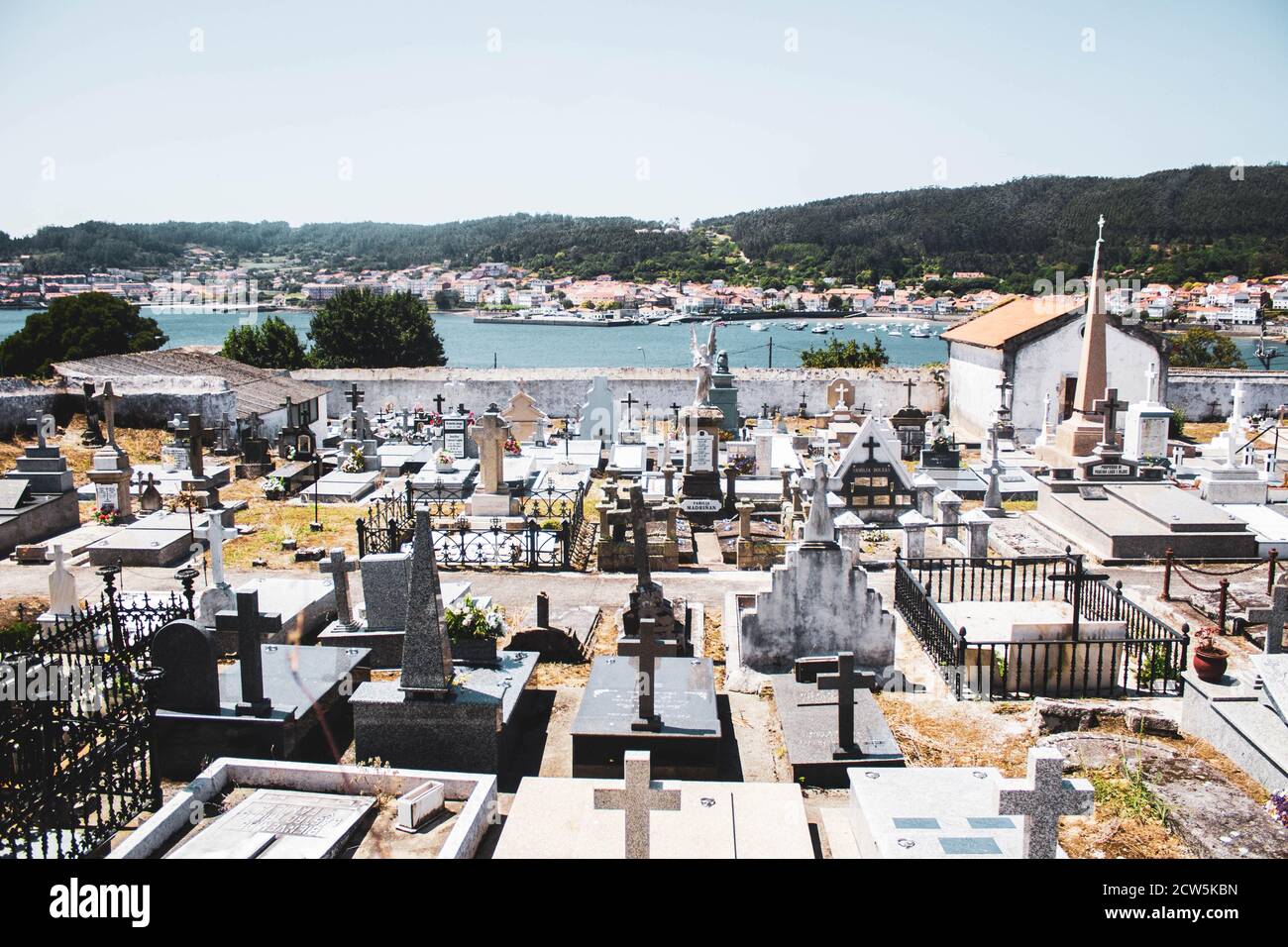 white graveyard by the sea against houses and mountains Stock Photo - Alamy