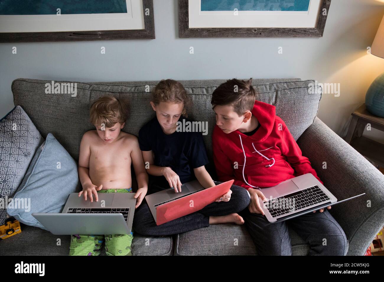 Siblings Work Together on Distance Learning at Home, Using Laptops ...