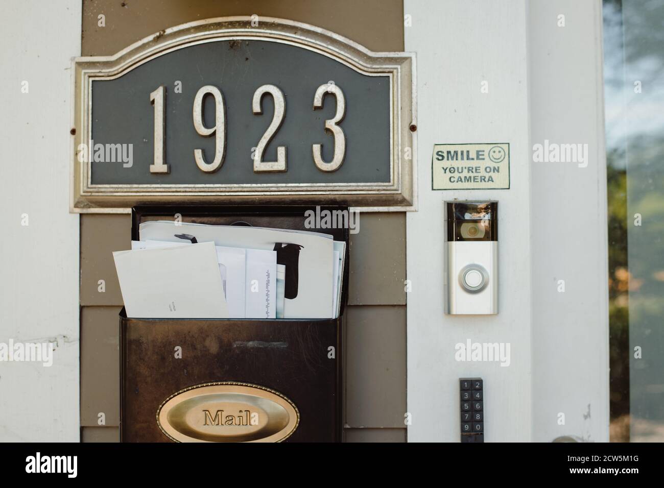 Front of house with overflowing mailbox, camera, and doorbell Stock ...