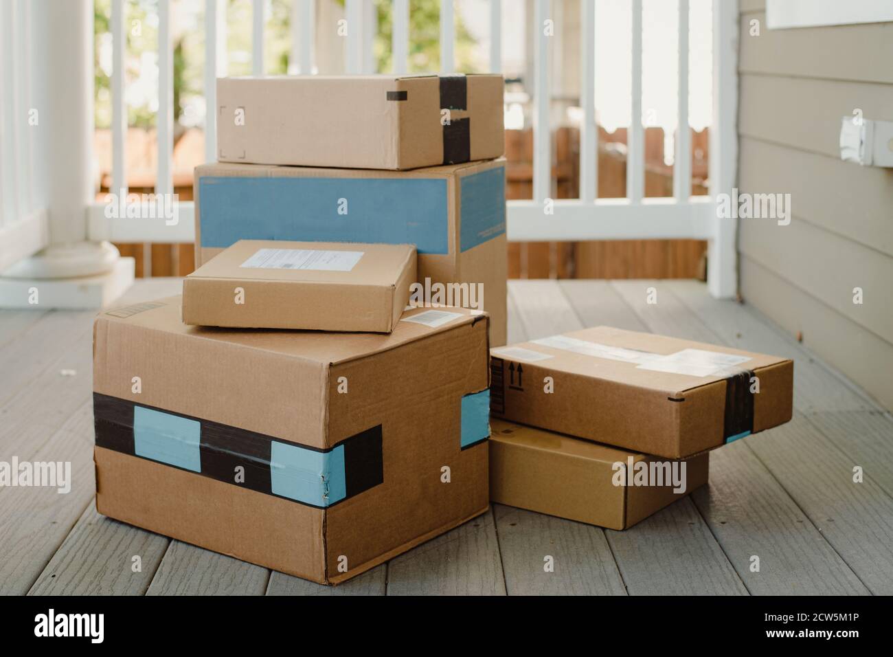 Stack of packages on front porch after mail delivery Stock Photo - Alamy