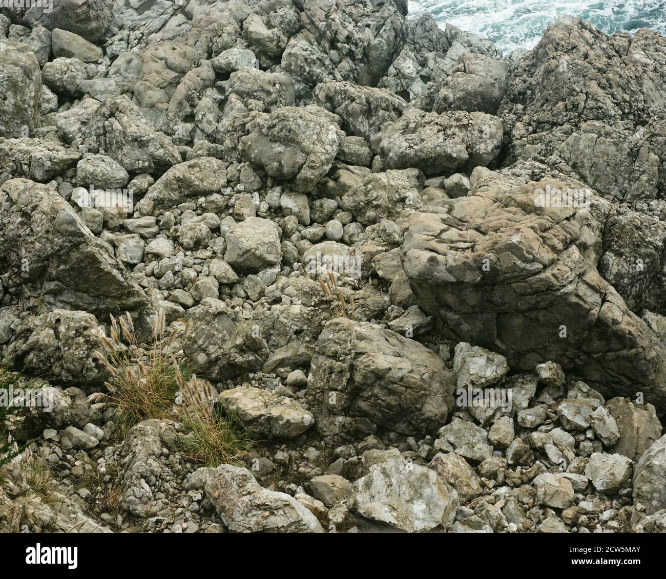 Sharp jagged rocks below by the ocean water Stock Photo - Alamy