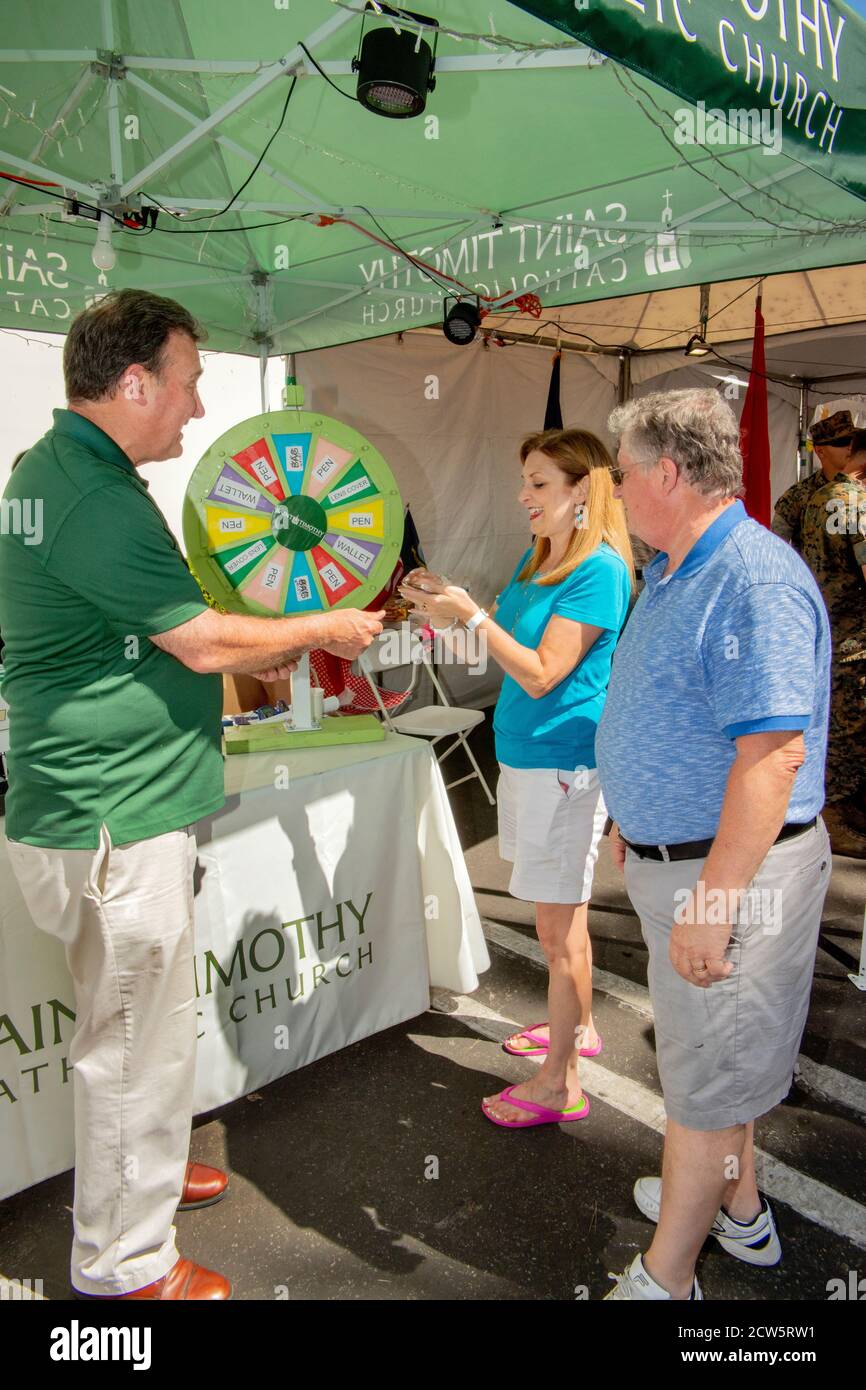 A Catholic deacon socializes with parishioners at a wheel of chance ...