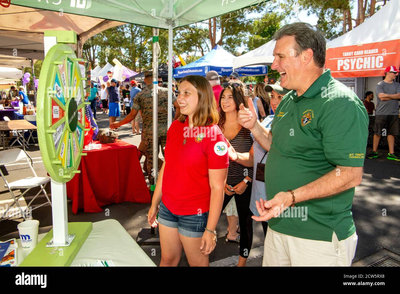 A Catholic deacon socializes with young parishioners at a wheel of ...