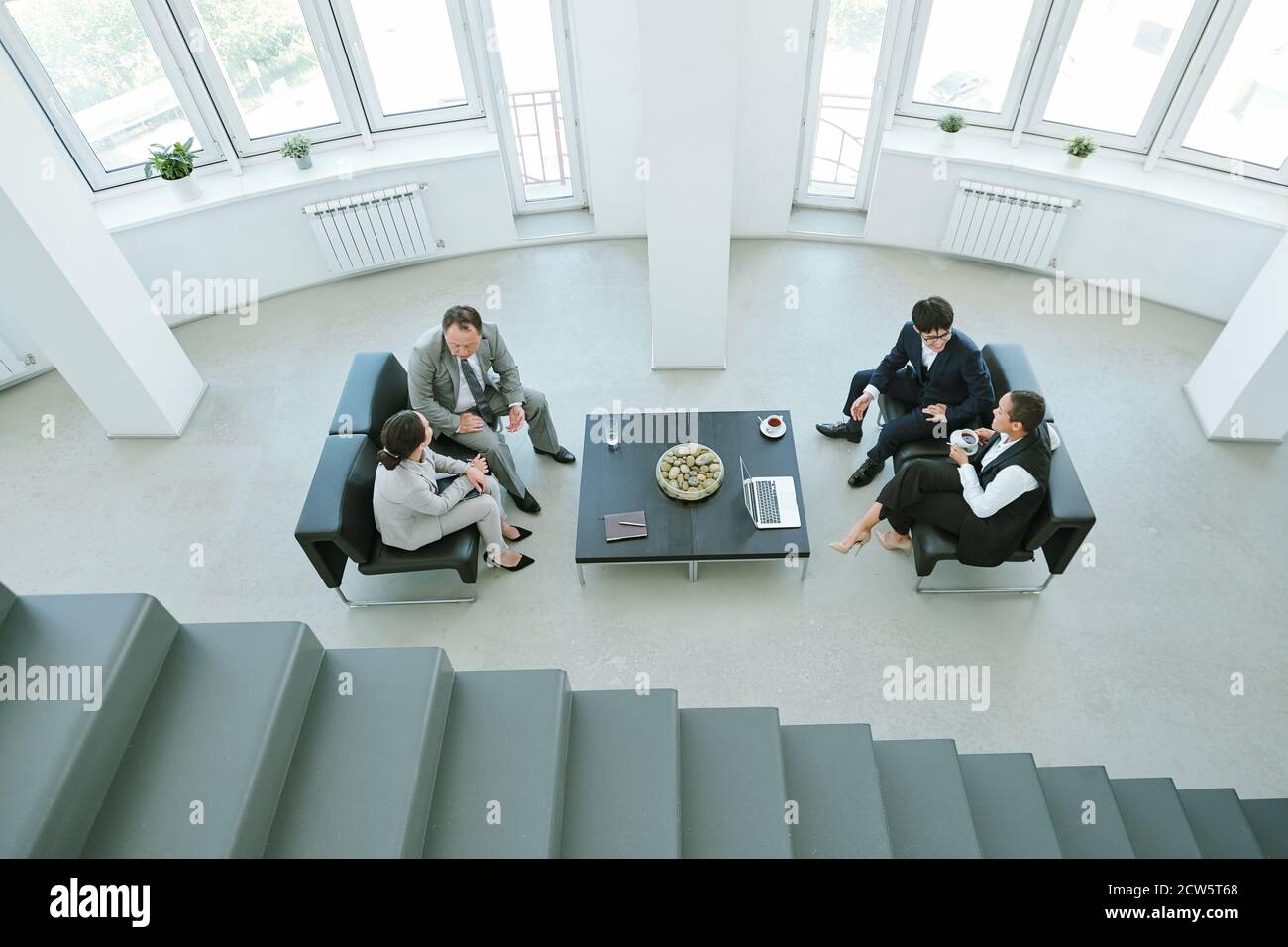 Two small groups of intercultural business partners talking after ...