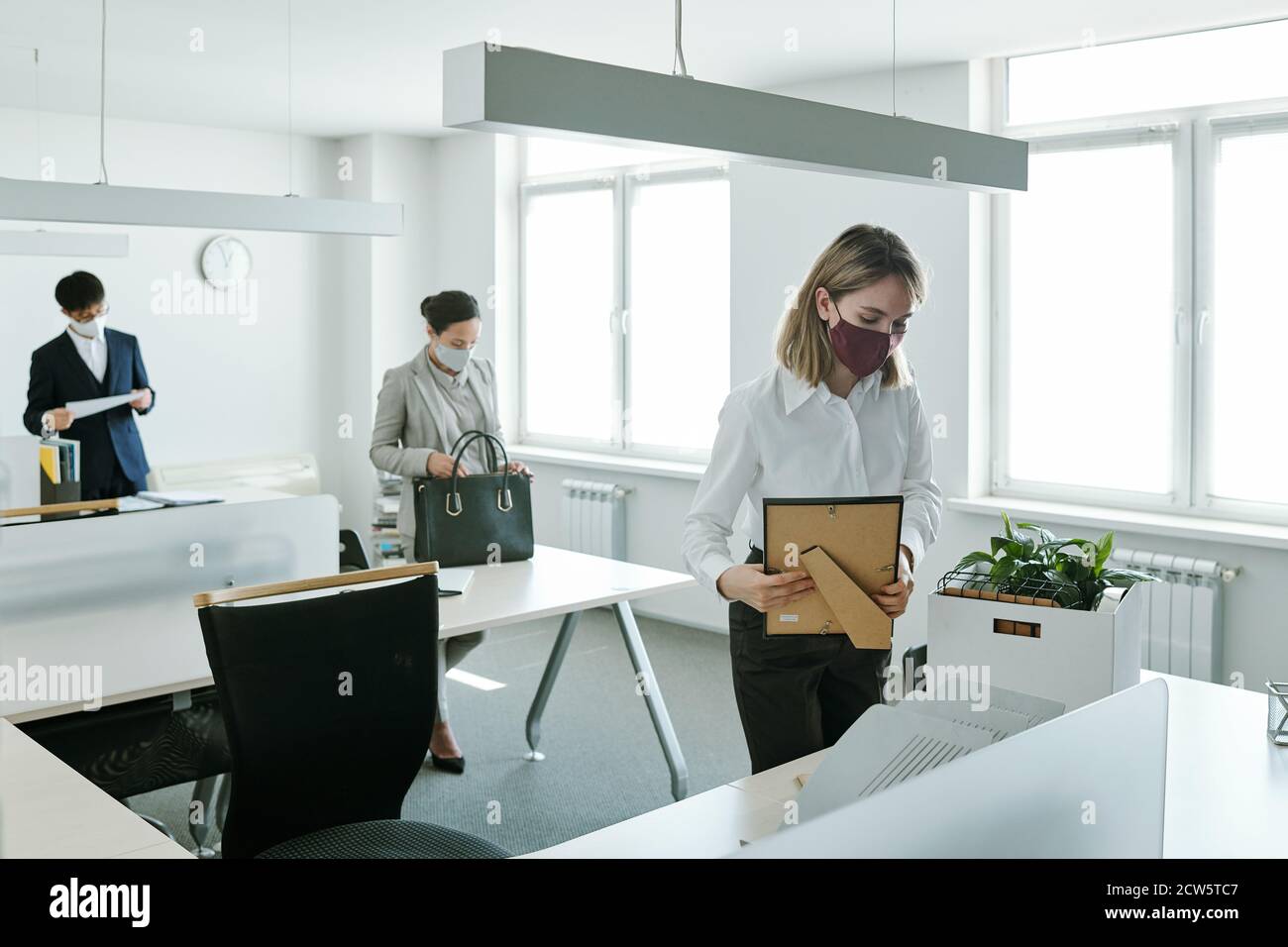 Group of contemporary business people taking out office supplies out of ...