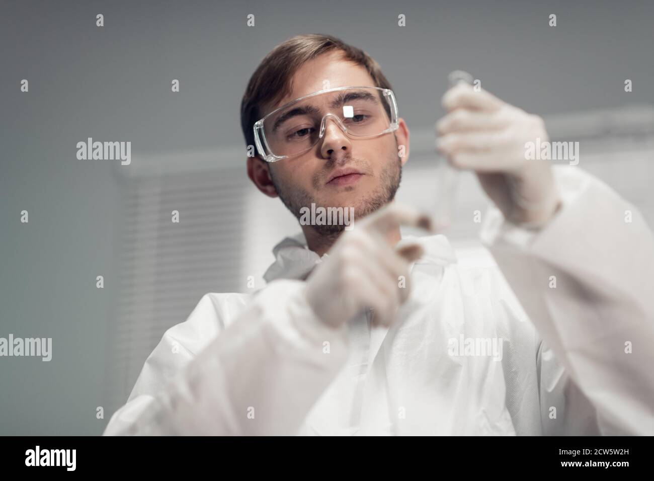 A close up portrait of a scientist injecting chemicals into a plastic ...