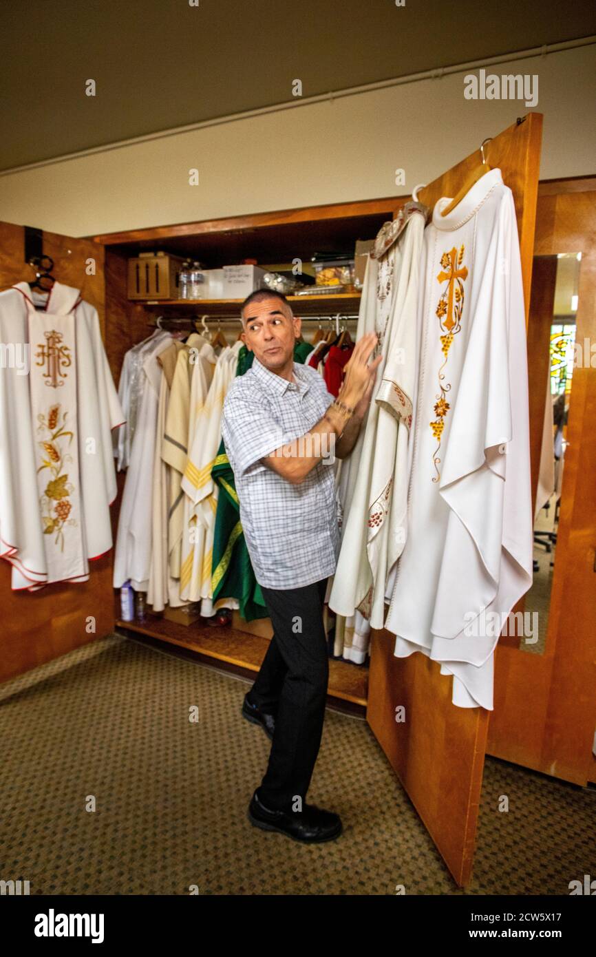A deacon selects vestments for his priest before mass at a Southern ...