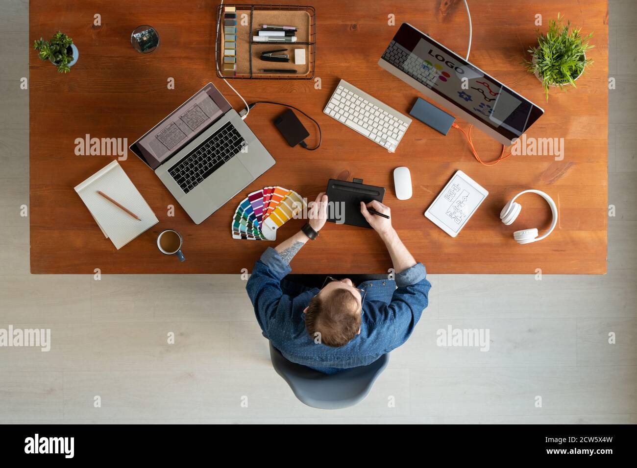 Overview of young creative software developer drawing on tablet display ...