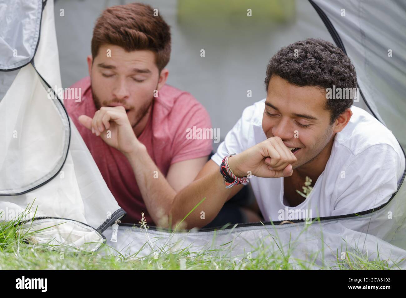 two teenage men waking up in a tent and yawning Stock Photo - Alamy