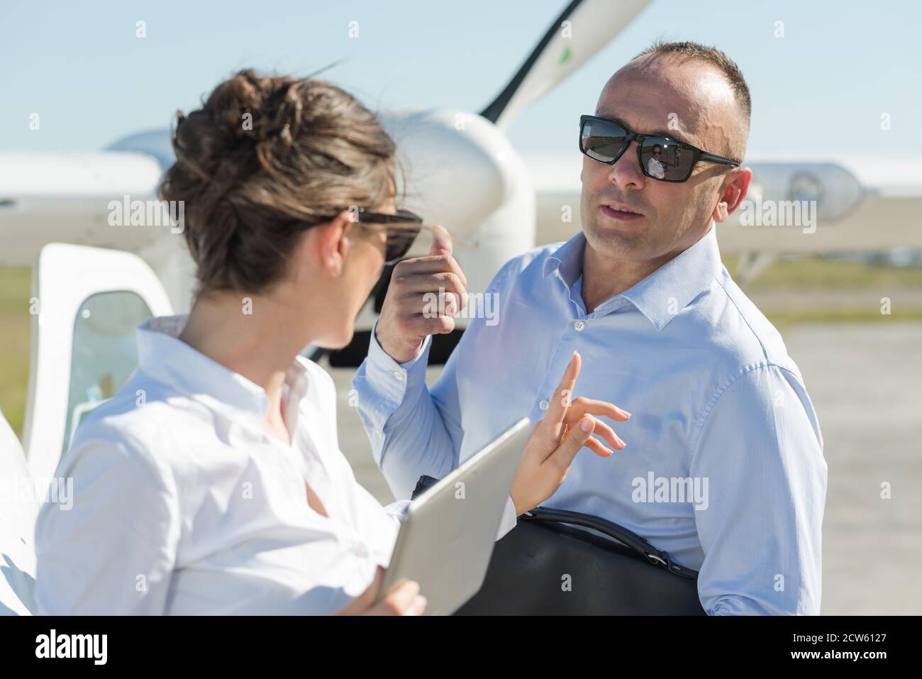 people talking outside private plane Stock Photo - Alamy