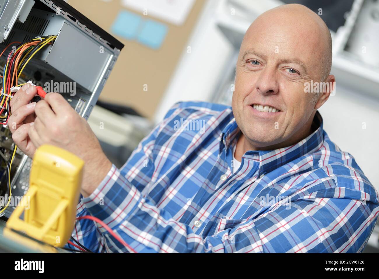 happy technician using multimeter for voltage on pc Stock Photo - Alamy