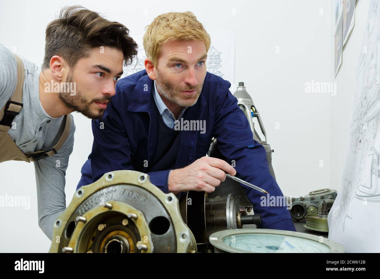 two mechanic men working on engine Stock Photo - Alamy