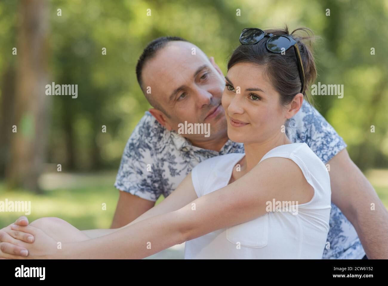 couple sat outdoors man looking adoringly at the woman Stock Photo - Alamy