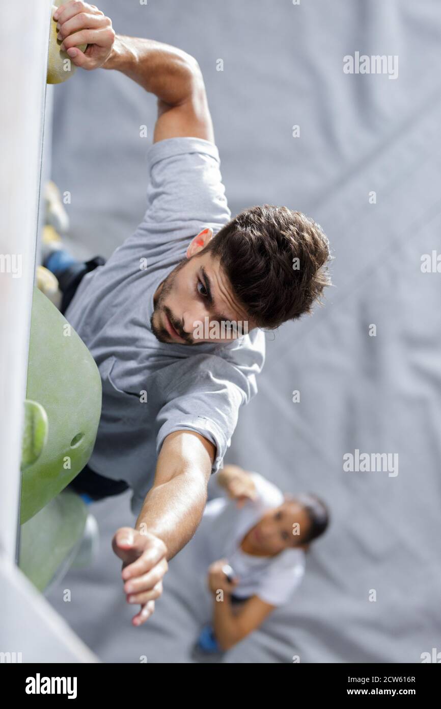 man climbing up on practice wall indoor Stock Photo - Alamy