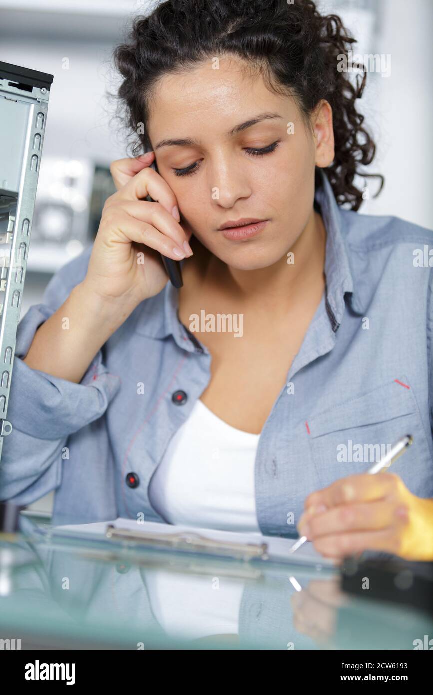 adult female working talking writing notes Stock Photo - Alamy