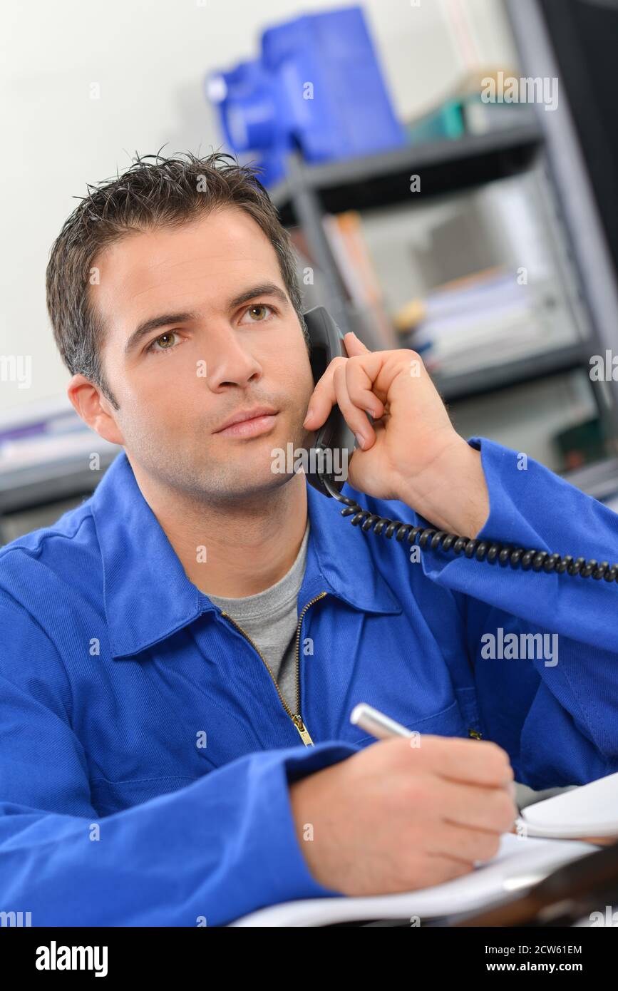 Builder taking notes during a call Stock Photo - Alamy