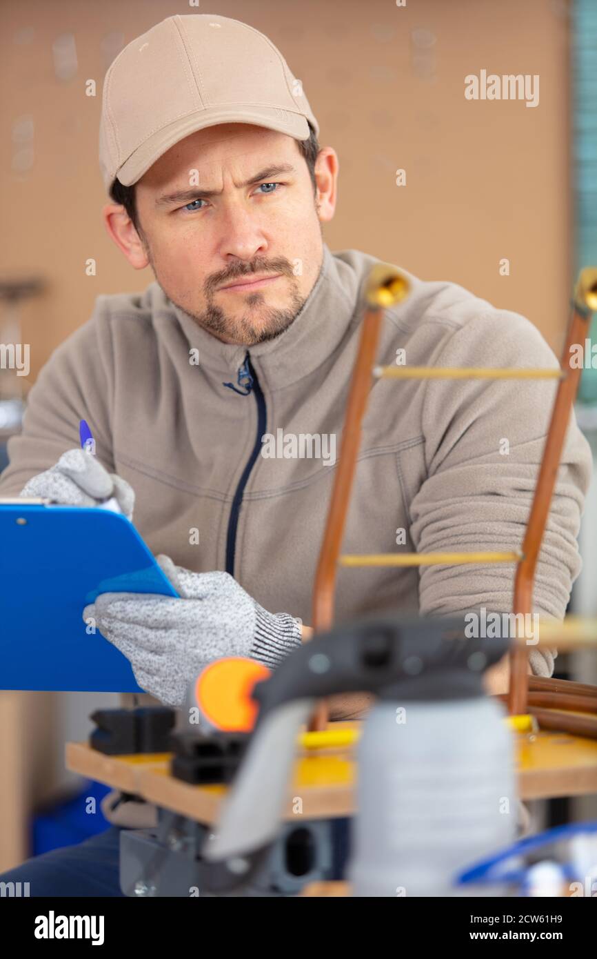 man builder writing on clipboard inspecting construction site Stock ...
