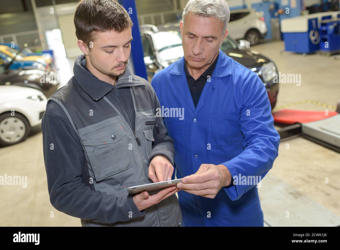 young apprentice mechanic and professor Stock Photo - Alamy