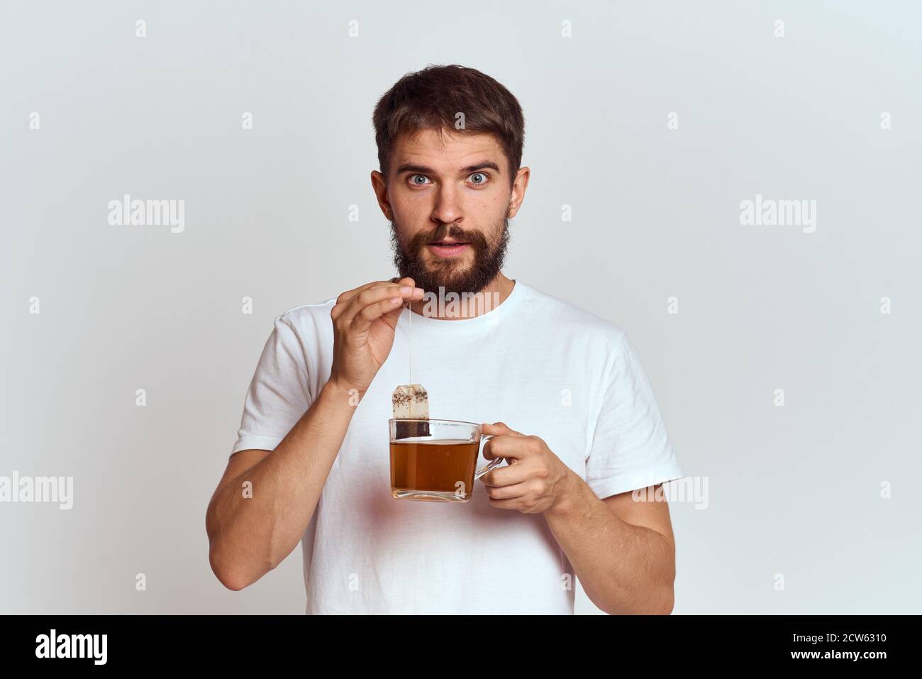 man with a cup of tea in a bag on a light background Hot drink cropped ...