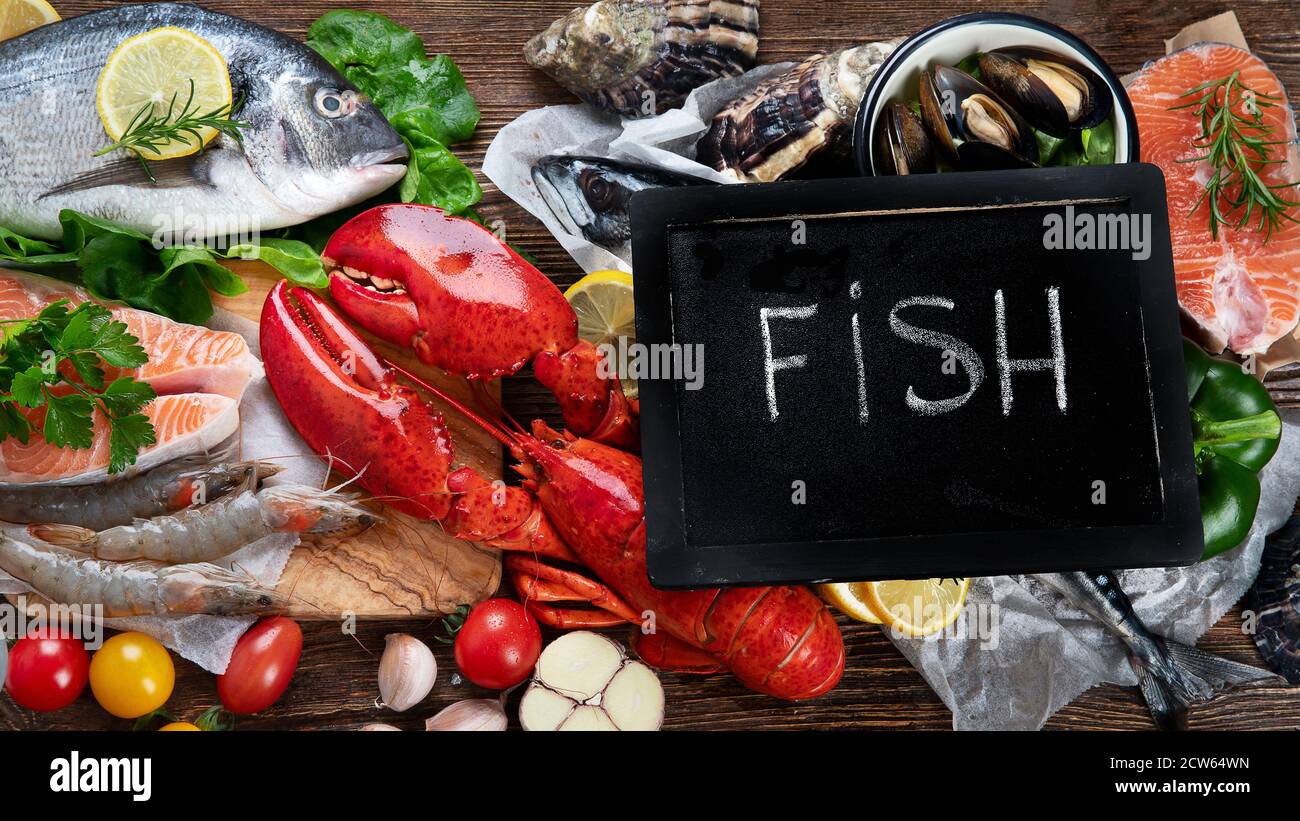 Fresh fish and seafood with herbs, spices and vegetables on rustic ...