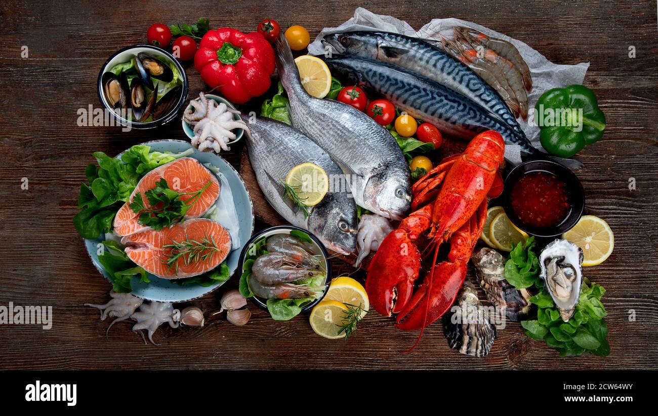 Fresh fish and seafood with herbs, spices and vegetables on rustic ...