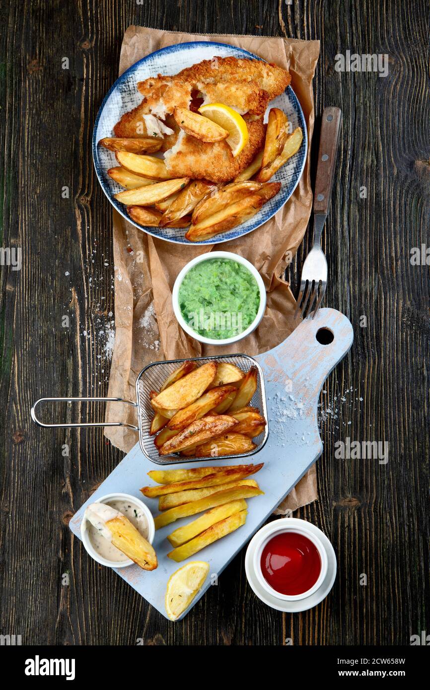 British traditional cuisine fish and chips. Served with mashed peas and ...