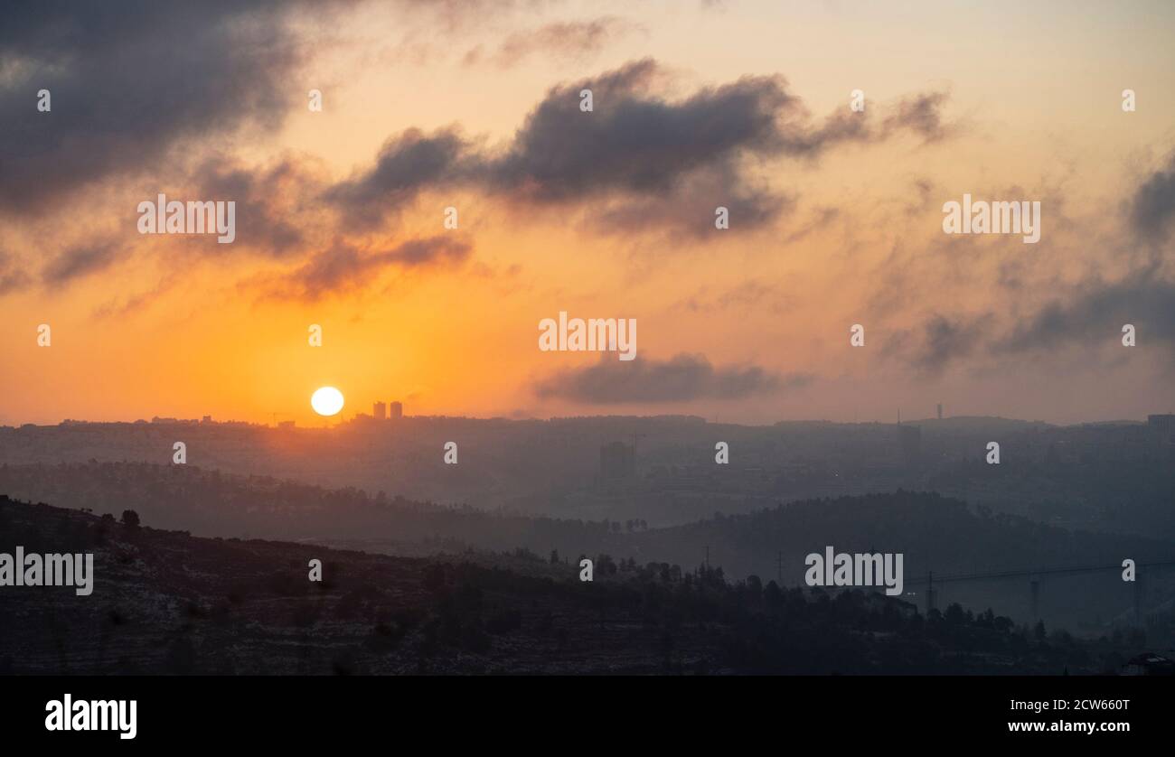 A cloudy sunrise over Jerusalem, Israel and the hazy Judea mountain ...