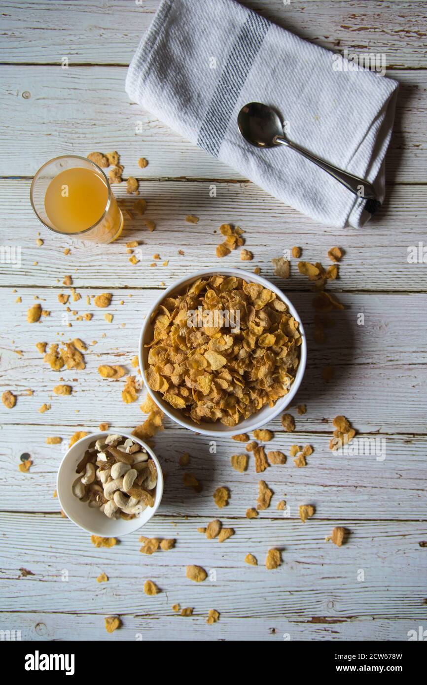 Vertical top view of dry fruits, juice and cornflakes on a background ...