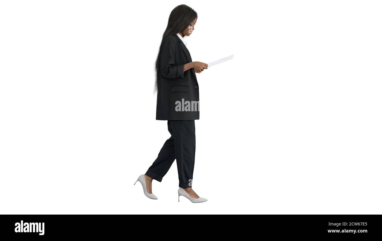 Serious african american woman reading documents while walking o Stock ...
