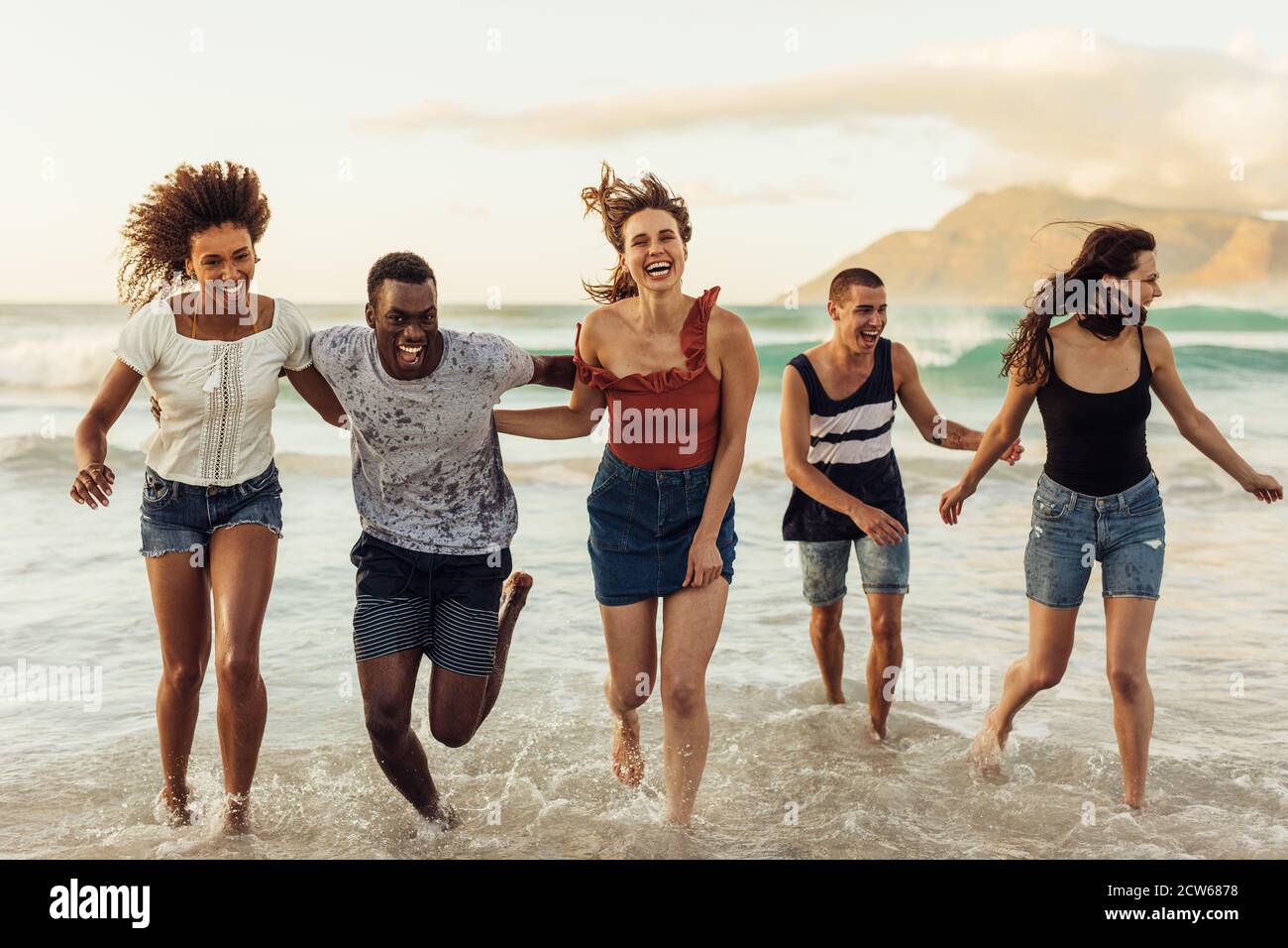 Friends enjoying at the beach on a holiday. Multiethnic friends on ...