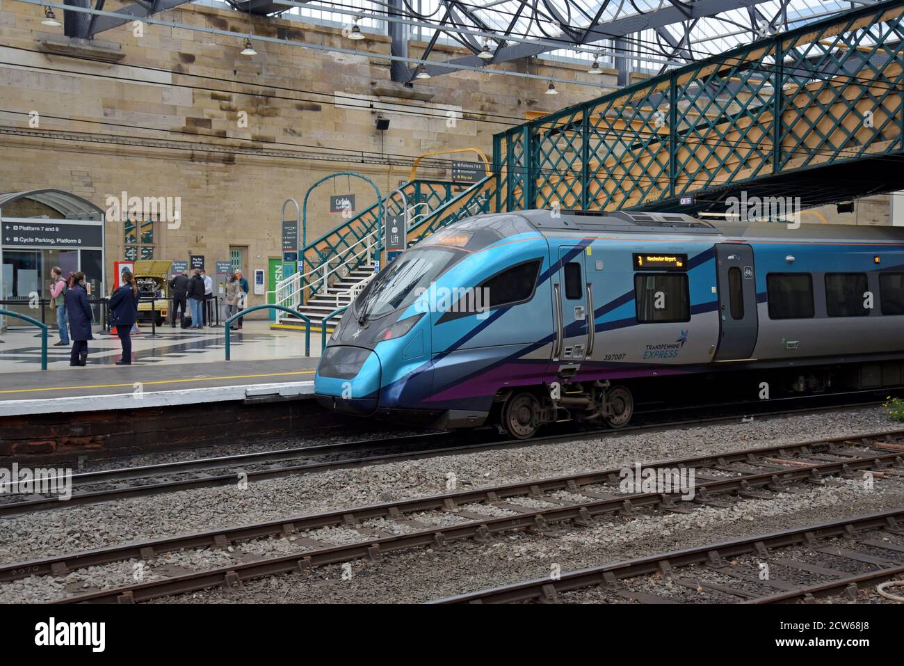 Passengers on the platform beside a Trans Pennine Express Class 397 ...