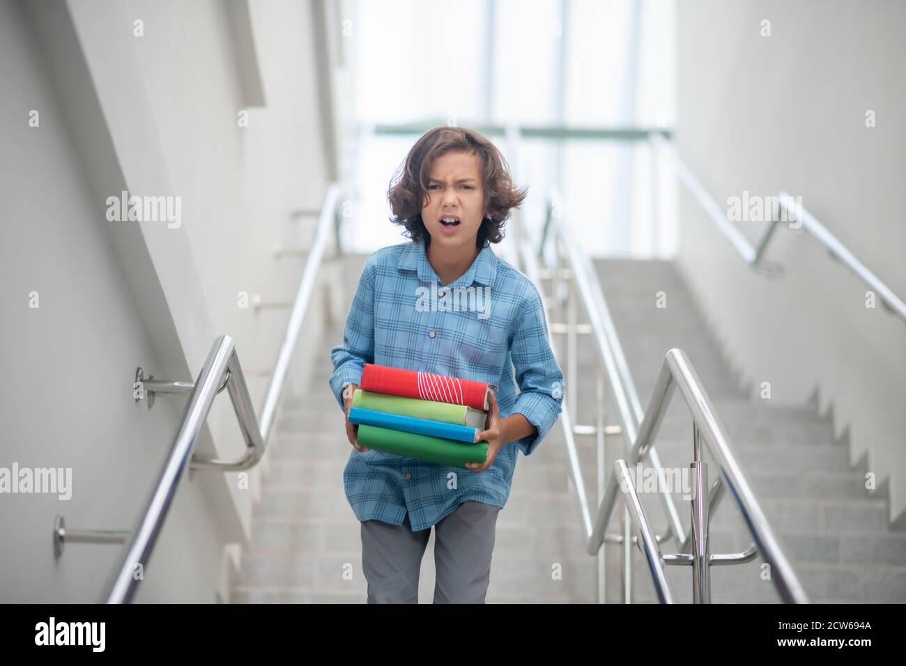 Boy carrying book hi-res stock photography and images - Alamy