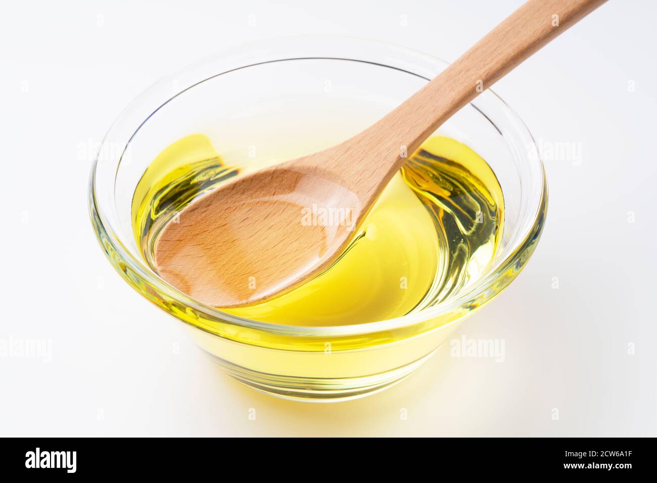 Vegetable oil and wooden spoon on a white background Stock Photo - Alamy