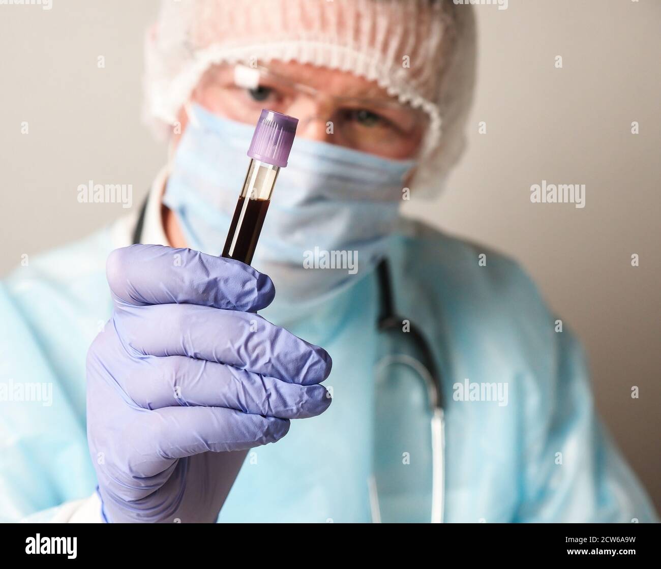 Medical laboratory specialist wearing protective gear with a blood test ...