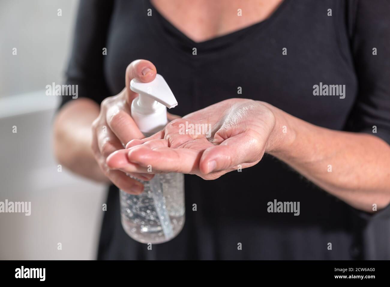 Female hand pressing on sanitizer alcohol gel bottle; prevention of ...