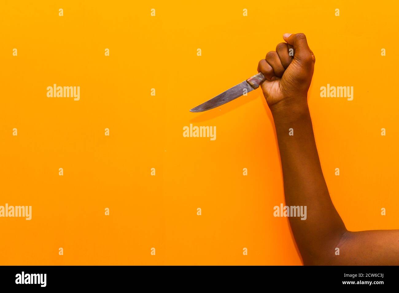 The human hand holding the knife isolation on Orange background ...