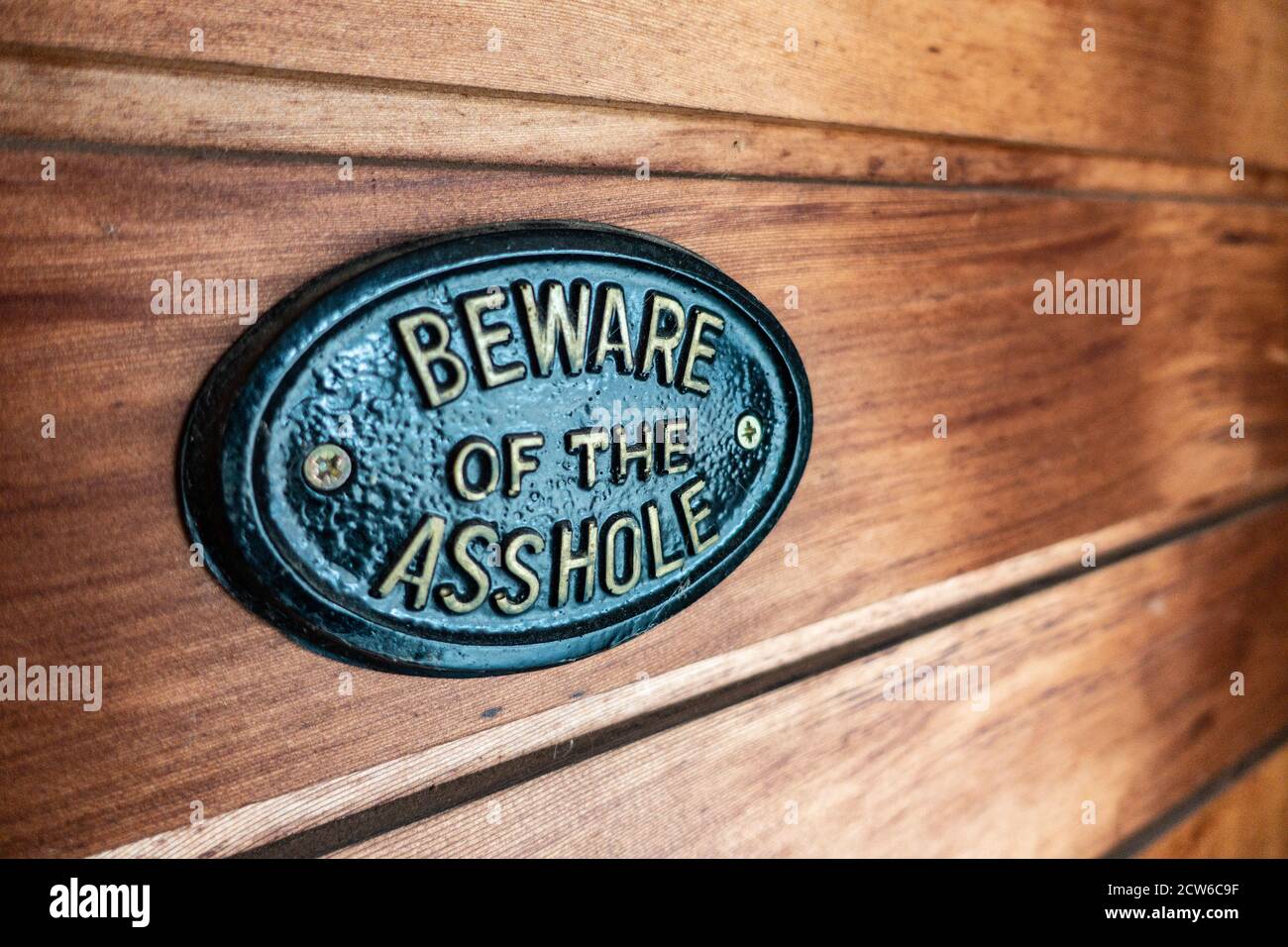 Beware of the asshole metal sign on door Stock Photo - Alamy