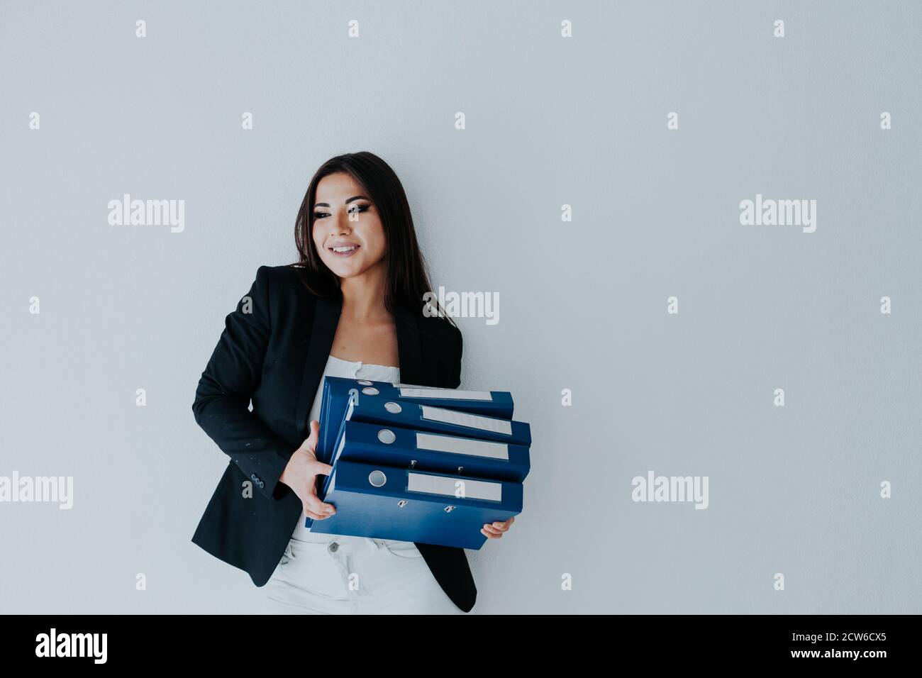 Beautiful brunette woman in business suit with paper folders in the ...