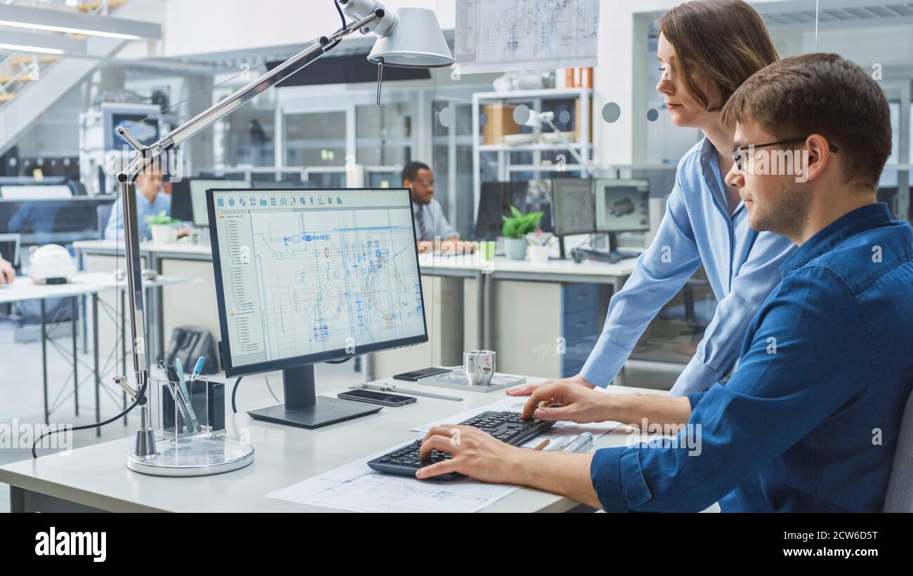 Engineer Talking With Project Manager and Working on Desktop Computer Using CAD Software with ...