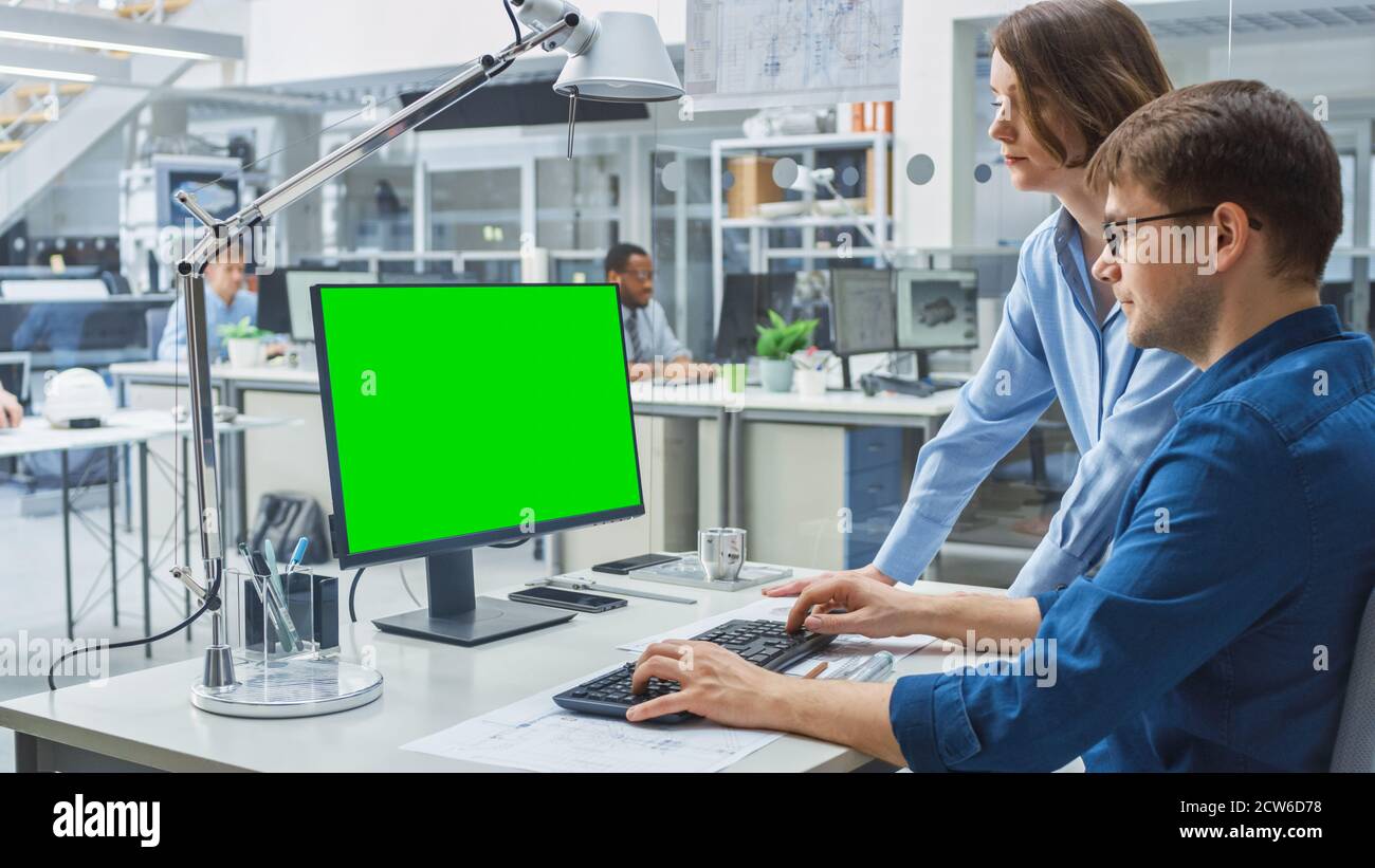 Engineer Talking With Project Manager and Working with Green Mock-up ...