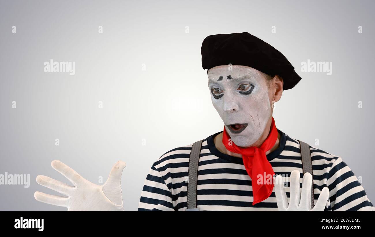 Young funny mime behind an invisible wall on gradient background Stock ...